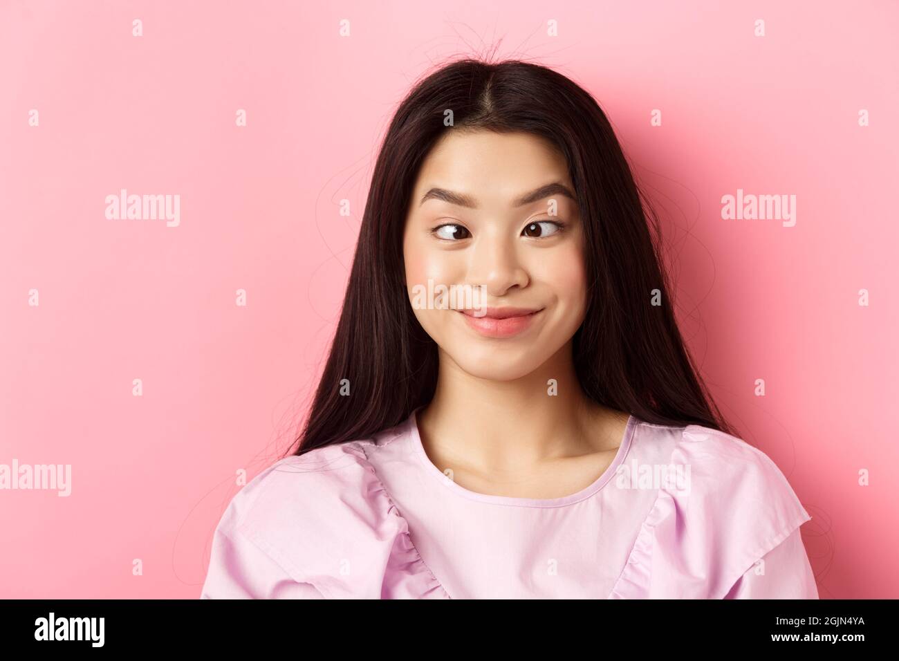 Close-up portrait of funny asian woman squinting eyes and making silly ...