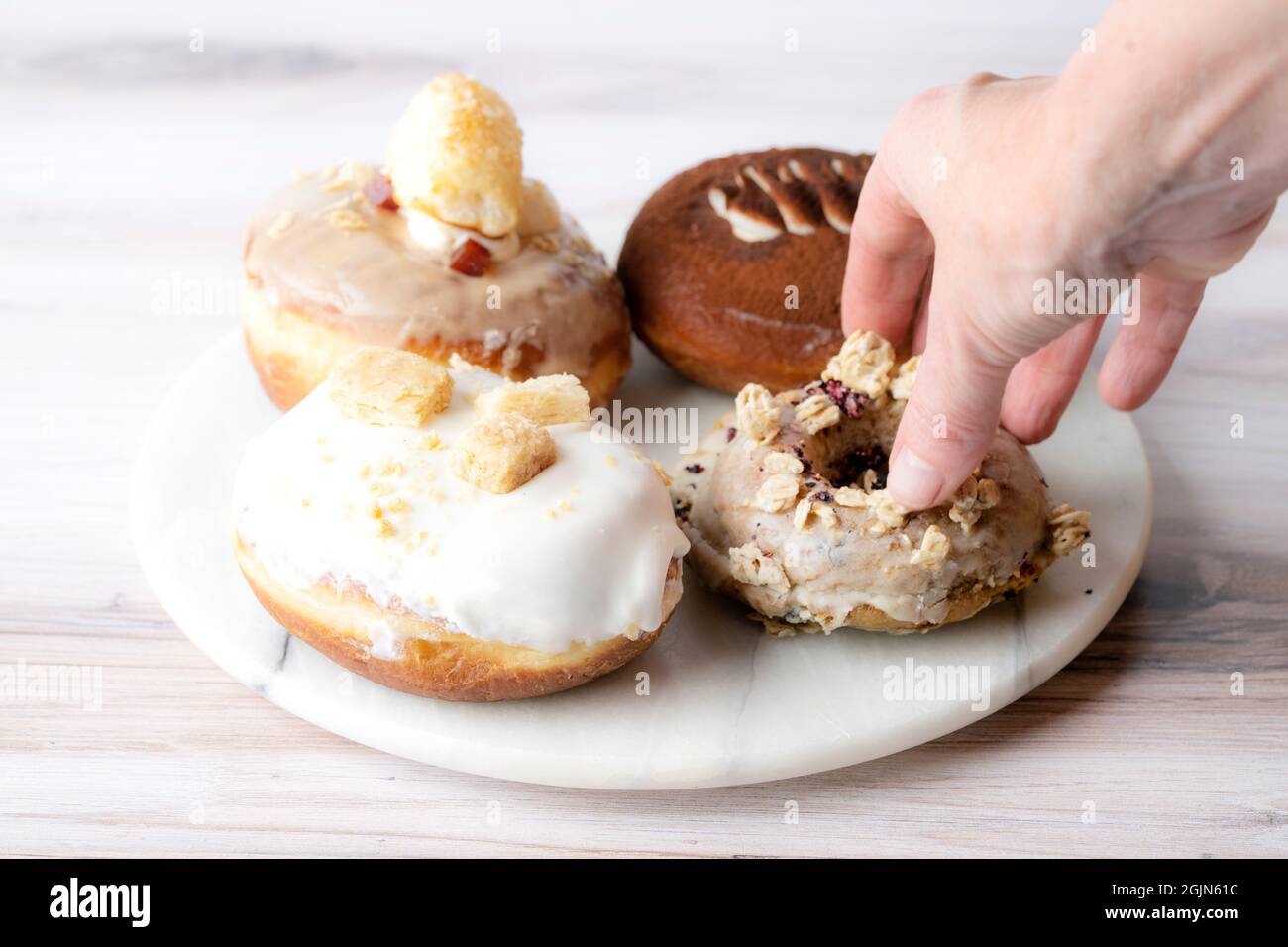 Hand grabbing donut hi-res stock photography and images - Alamy