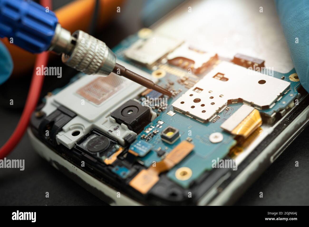 Technician repairing inside of mobile phone by soldering iron ...