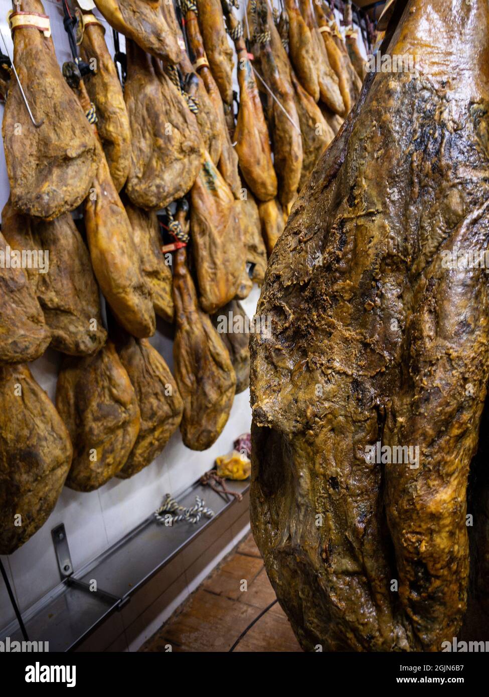 Dried pork thighs hang on the meat market. Spanish national dish of ham ...