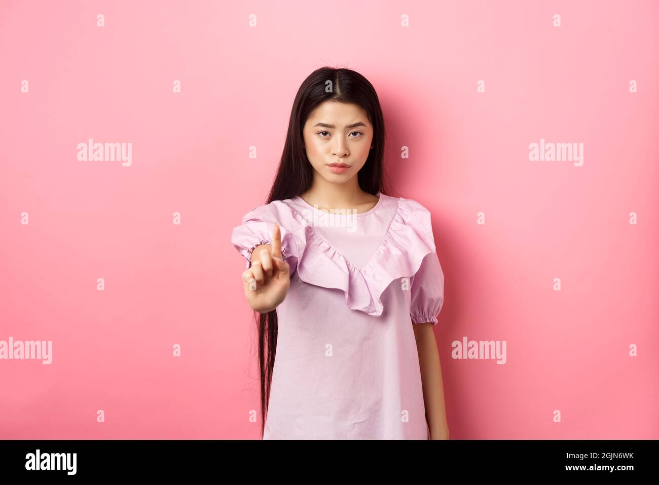 She says no. Serious asian girl shaking finger in stop gesture ...