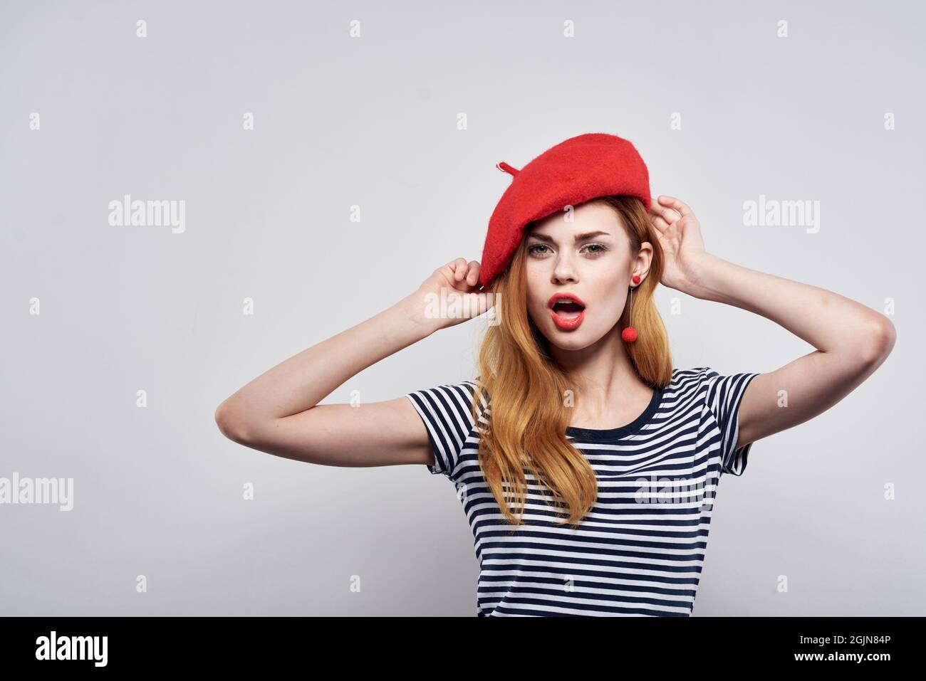 pretty woman in a striped t-shirt red lips gesture with his hands ...