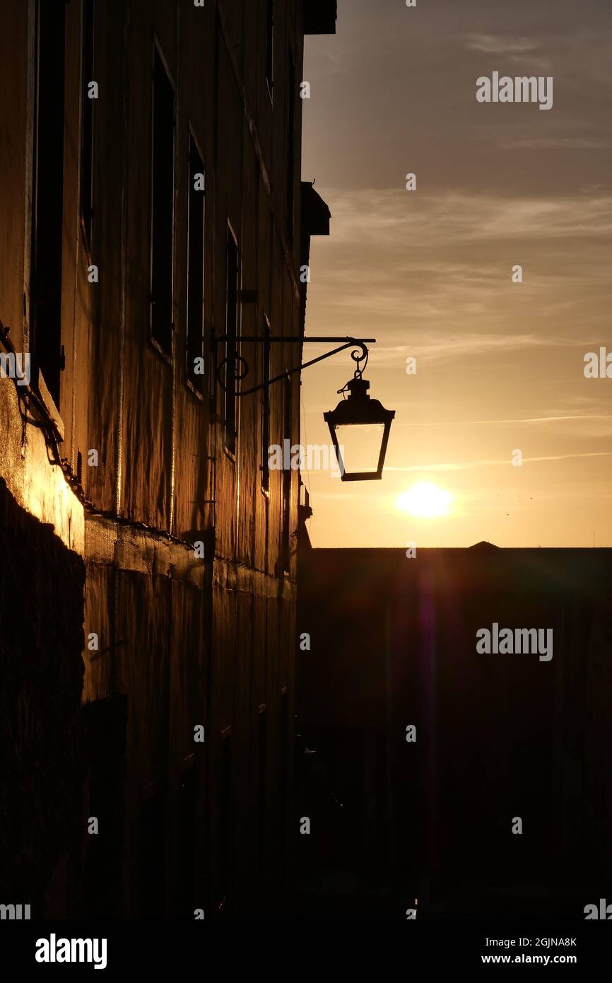 Vertical shot of light bulb hanging on wall against sunset Stock Photo ...