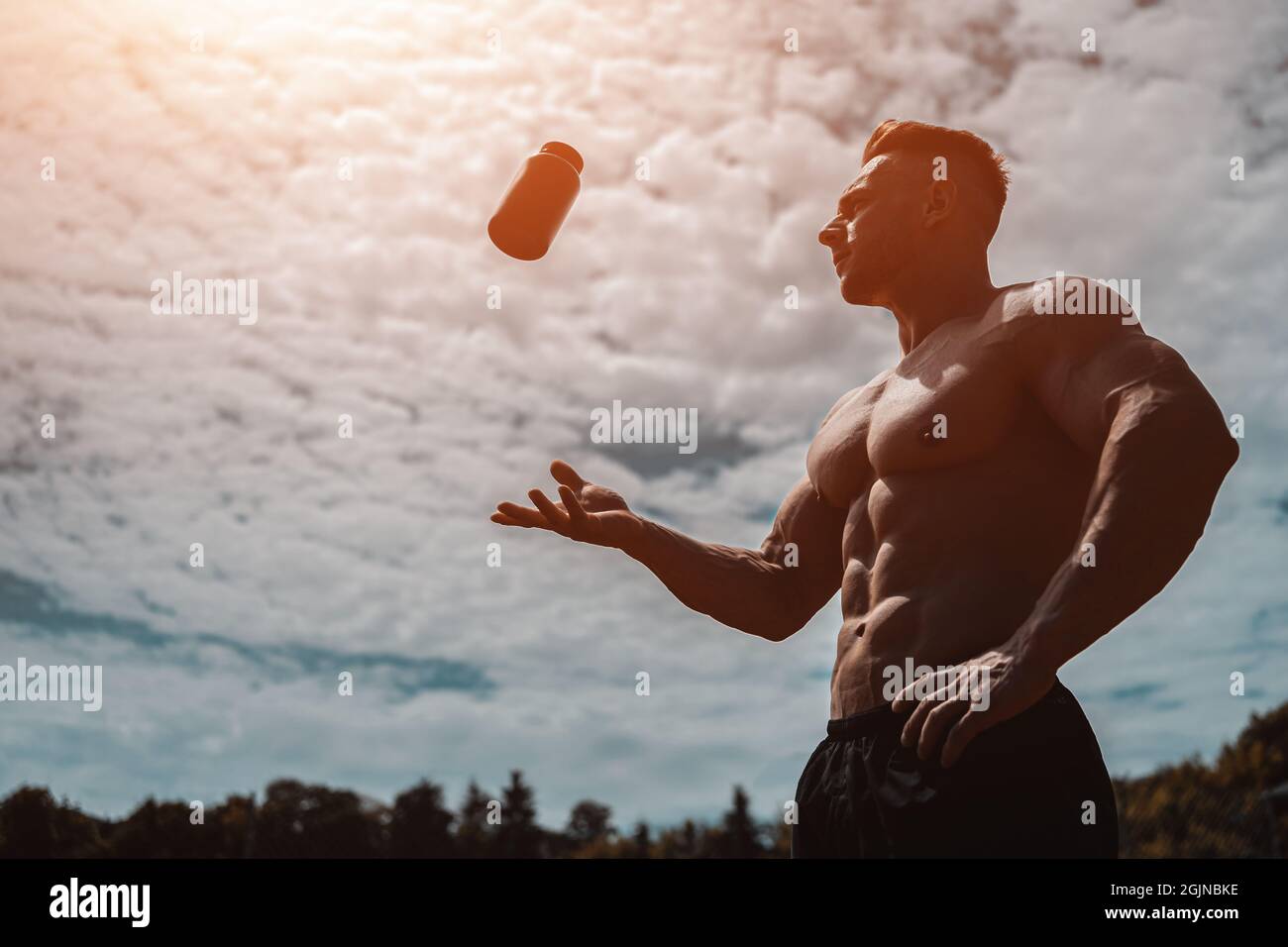 muscular athlete man throw up black container with protein whey powder ...