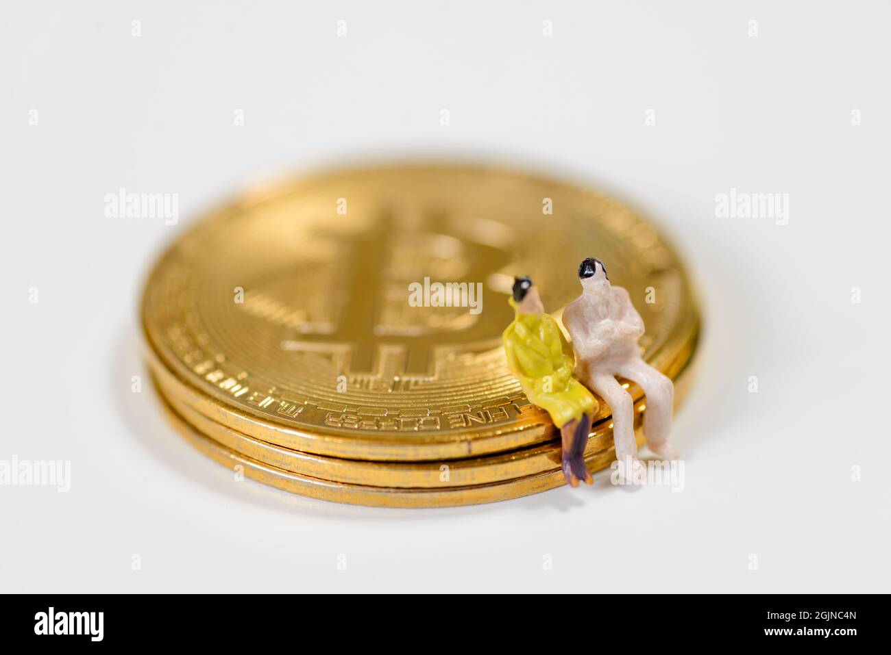 Two human figures sitting and talking on a crypto currency on white ...