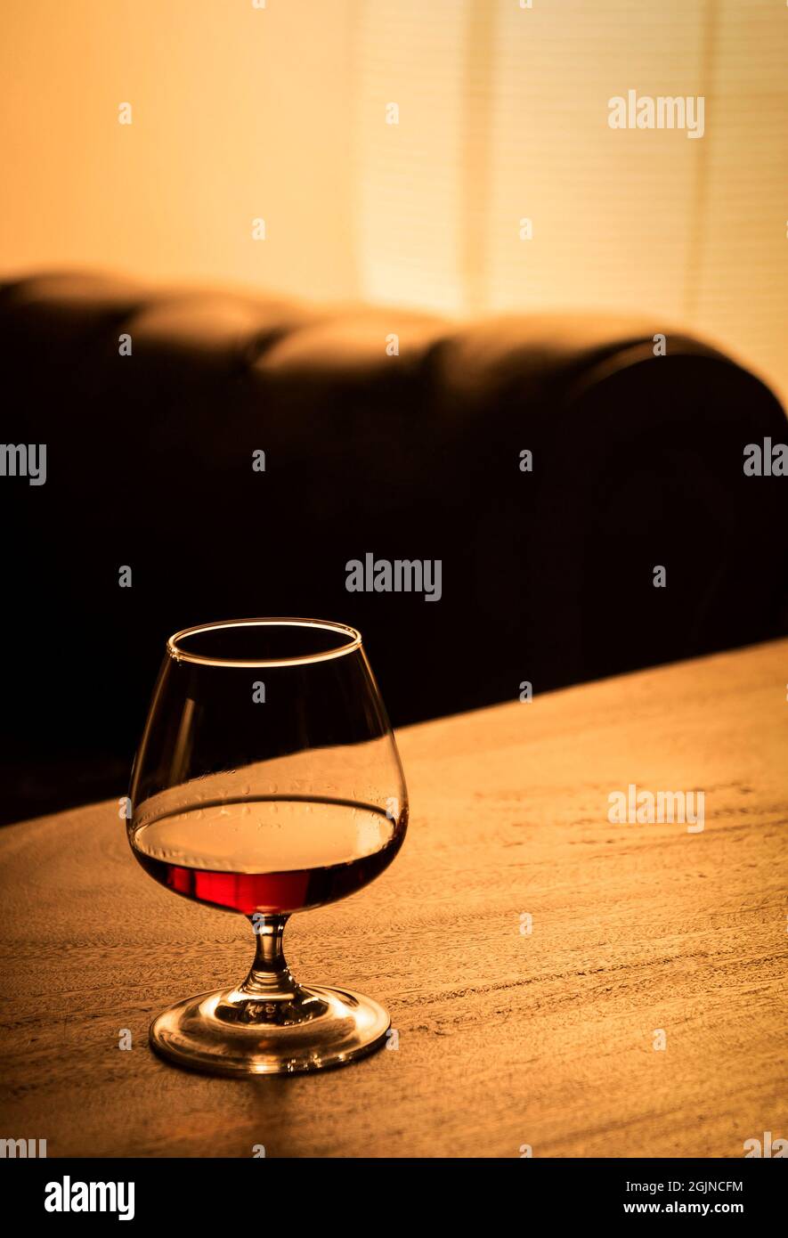 balloon glass of french cognac brandy on dark cozy bar table detail ...