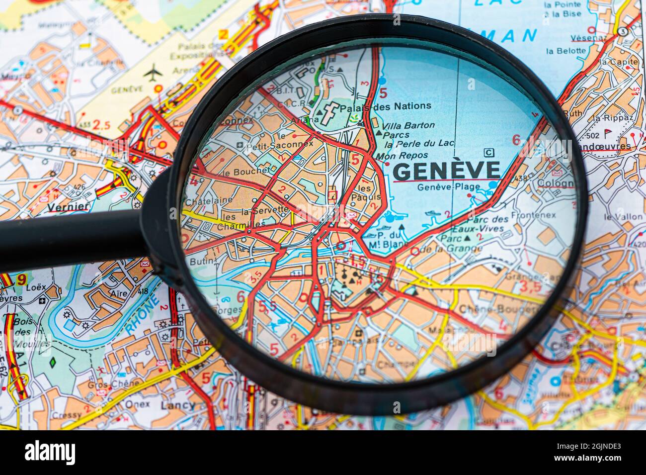 map of Geneva in Switzerland through magnifying glass, concept of ...