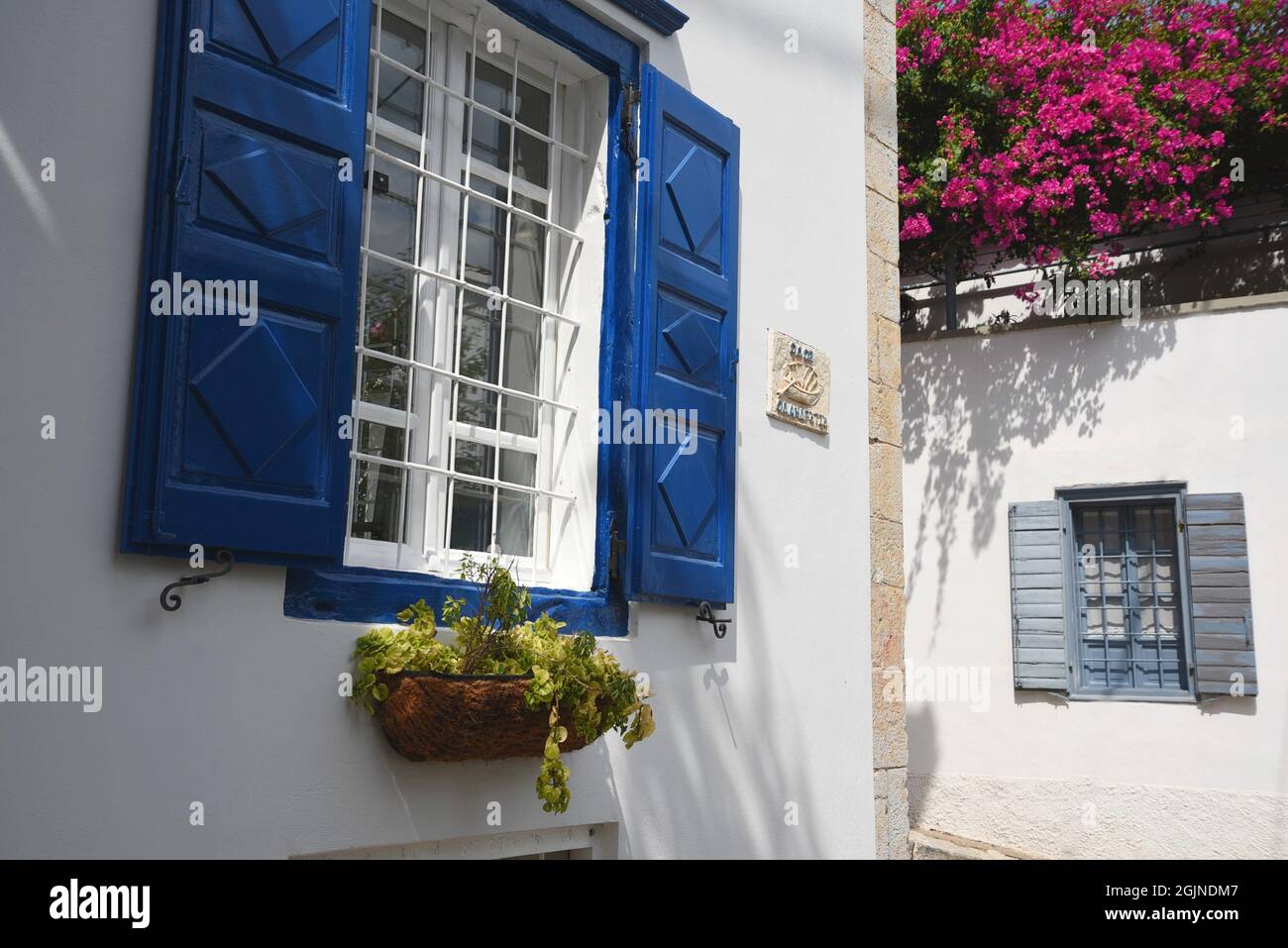Traditional rural house with a whitewashed wall, wooden window shutters ...
