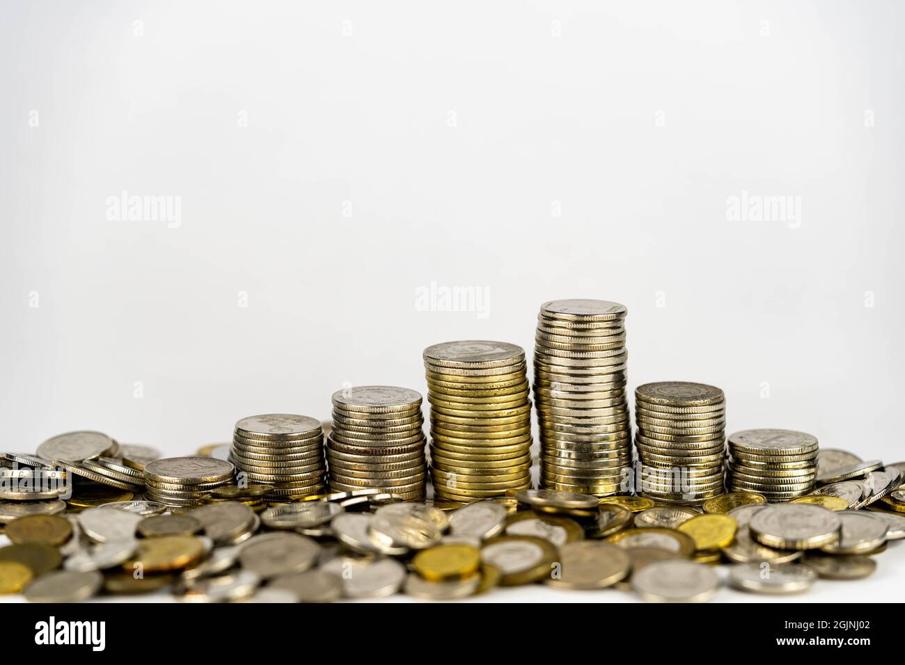 Coins scattered. Seven stacks of golden coins with different heights ...
