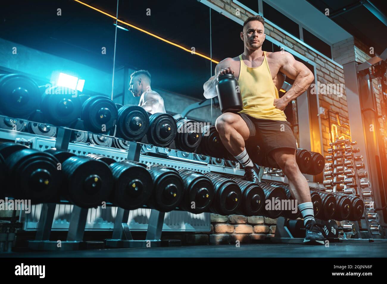 muscular bodybuilder male with protein whey powder in black container ...