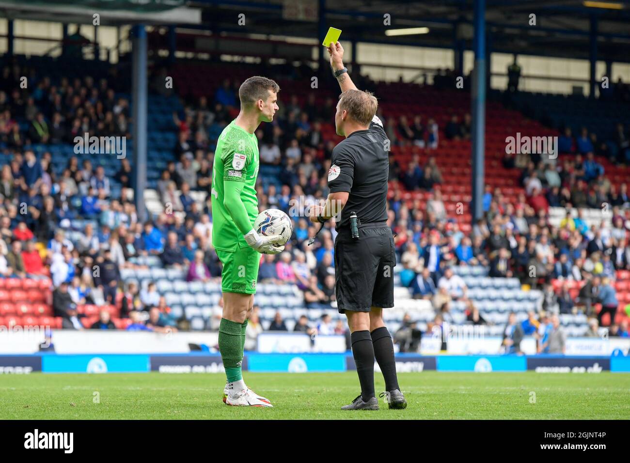 Simon Sluga #12 of Luton Town is shown a yellow card by referee Oliver ...