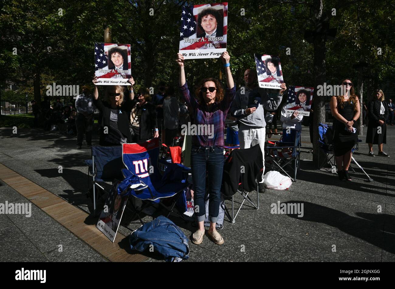 People hold signs remembering Wayne A. Russo at a ceremony at Ground ...