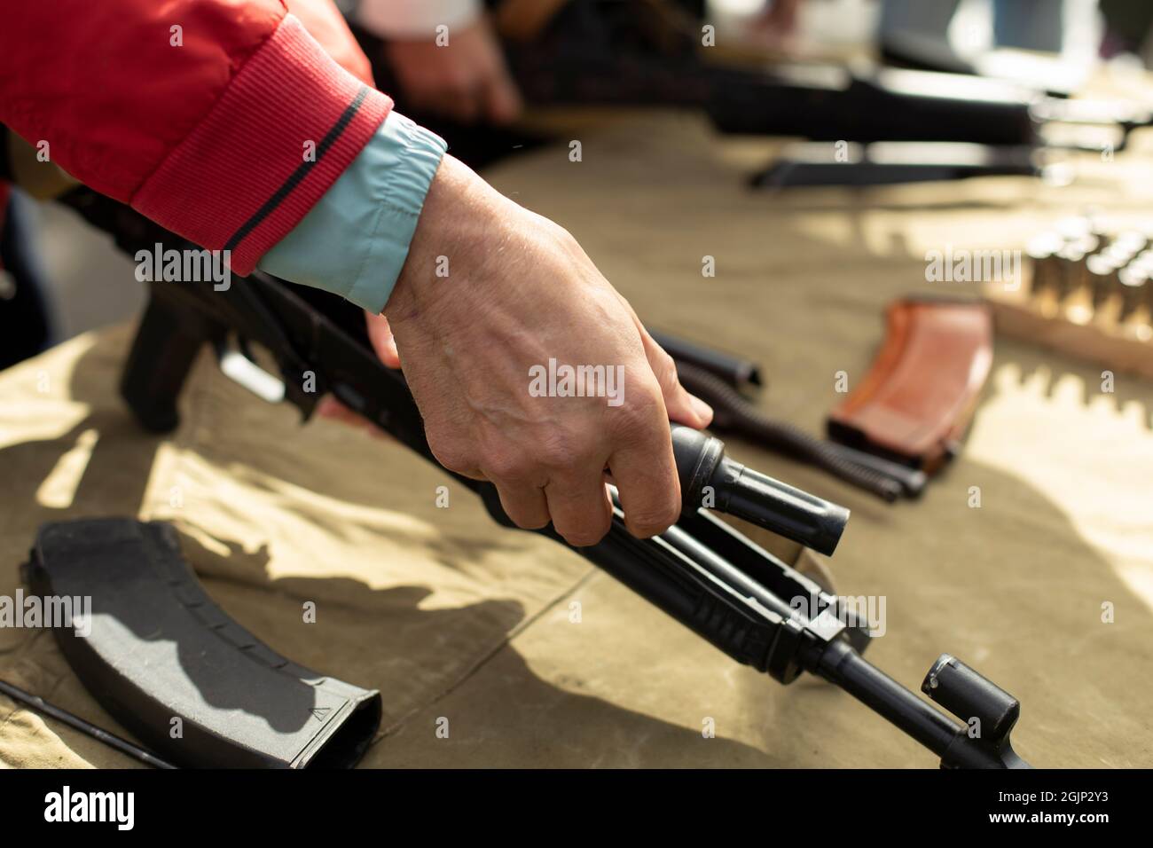 A man disassembles a firearm. A person undergoes military training ...