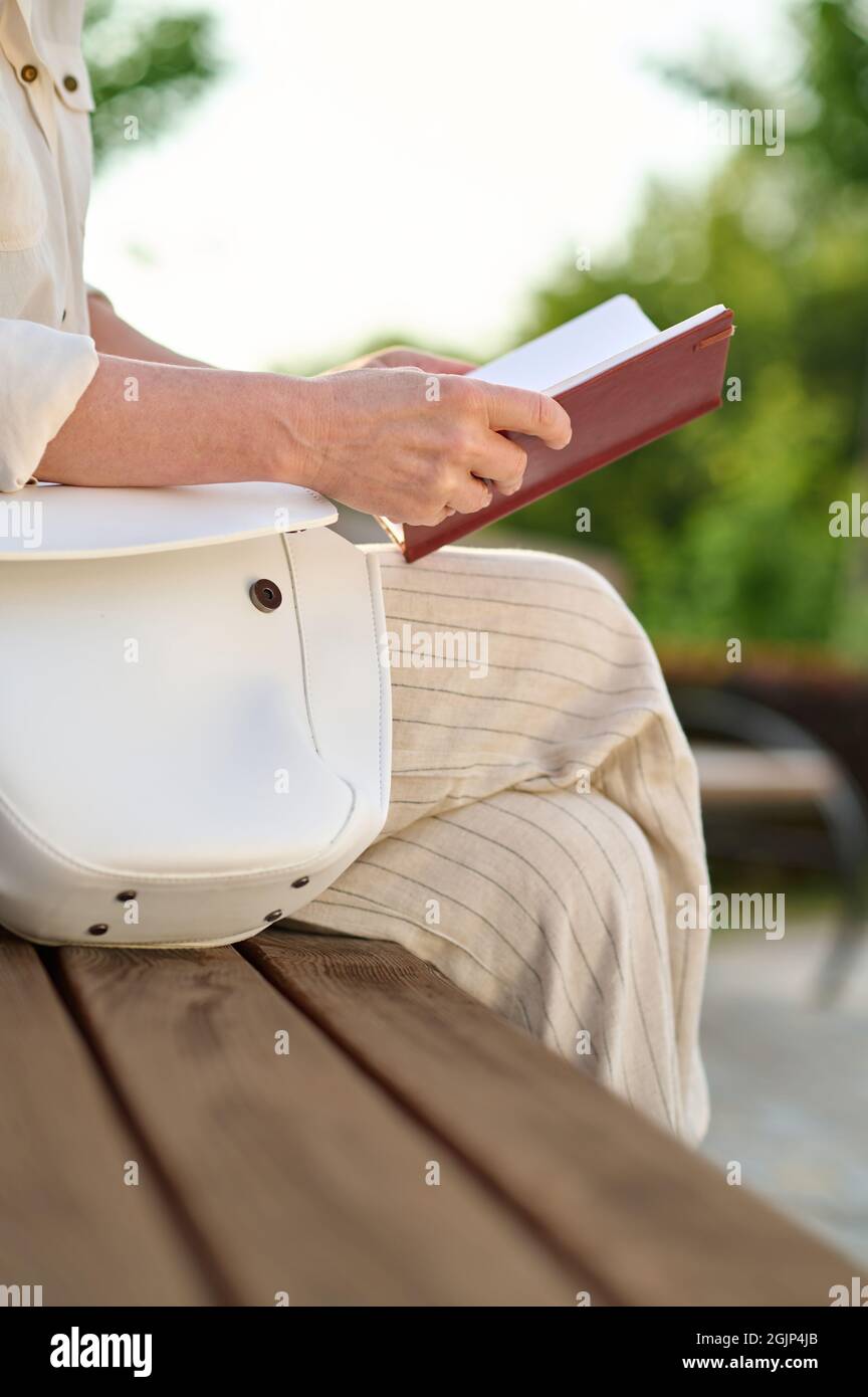Woman reading notes sitting on bench Stock Photo - Alamy