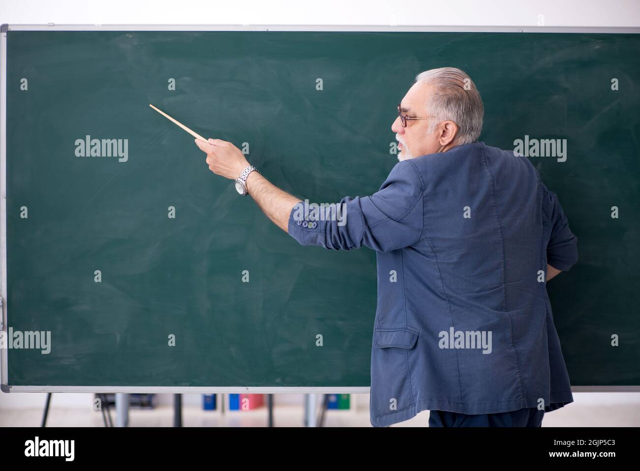 Old teacher in the classroom Stock Photo - Alamy