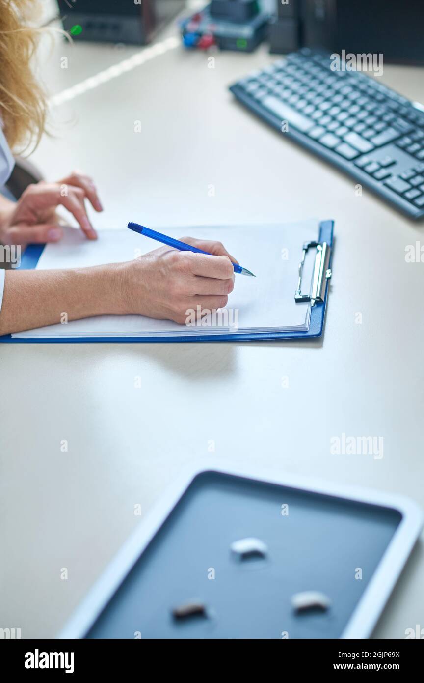 Doctors hand writing note in work notebook Stock Photo - Alamy