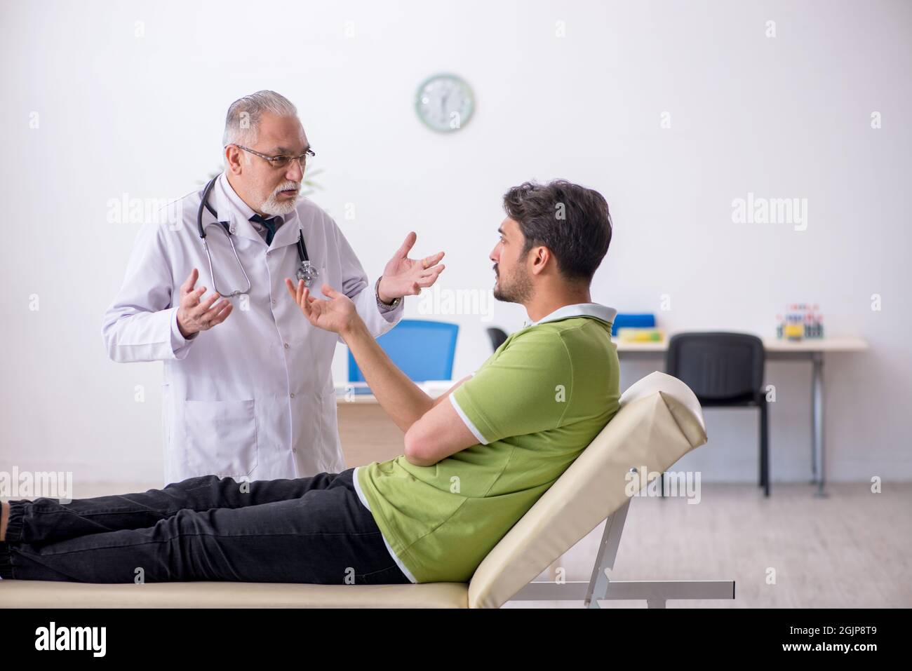 Young man visiting old doctor Stock Photo - Alamy