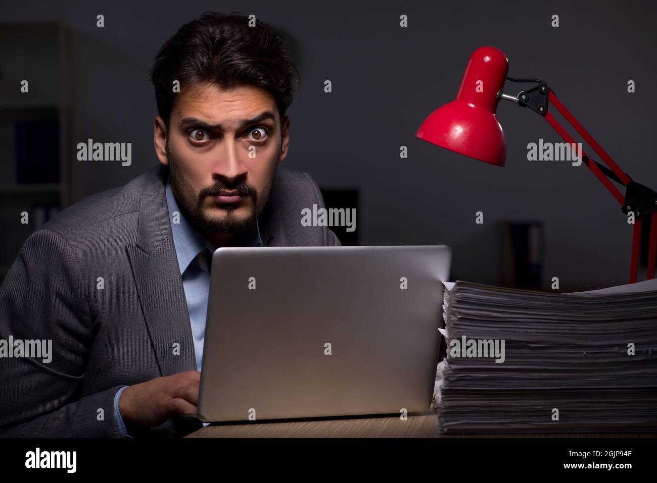 Young employee working late in the office Stock Photo - Alamy