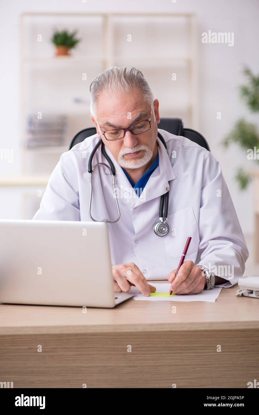 Old doctor working in the clinic Stock Photo - Alamy