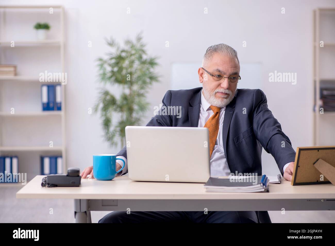 Old businessman employee missing his wife at workplace Stock Photo - Alamy