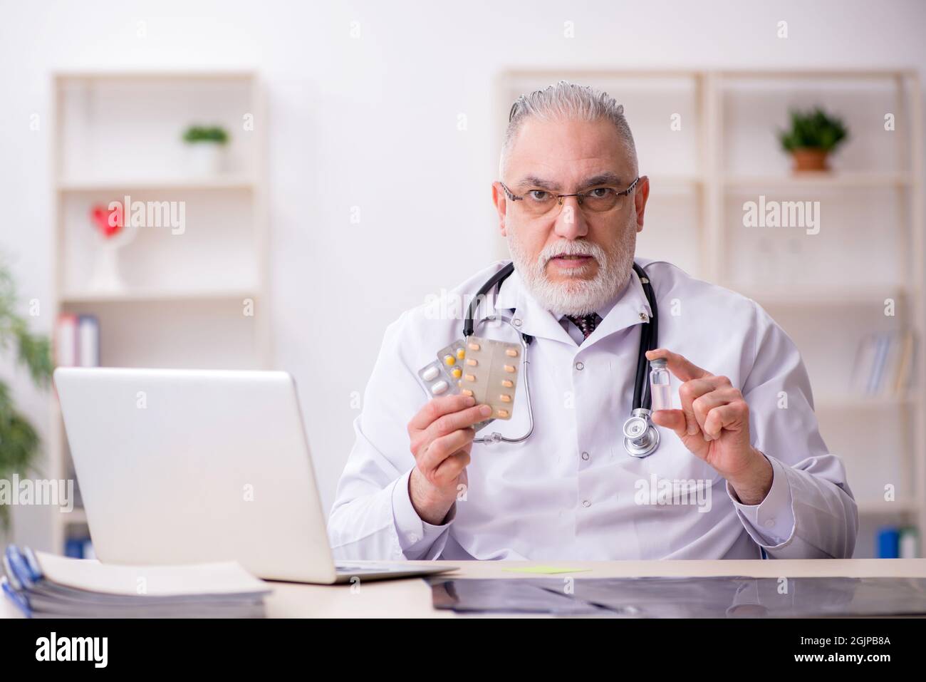 Old doctor working in the clinic Stock Photo - Alamy