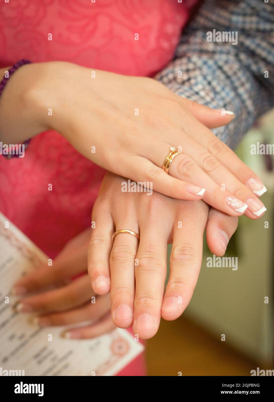 Hands of newlyweds with wedding rings also hold certificate on marriage ...