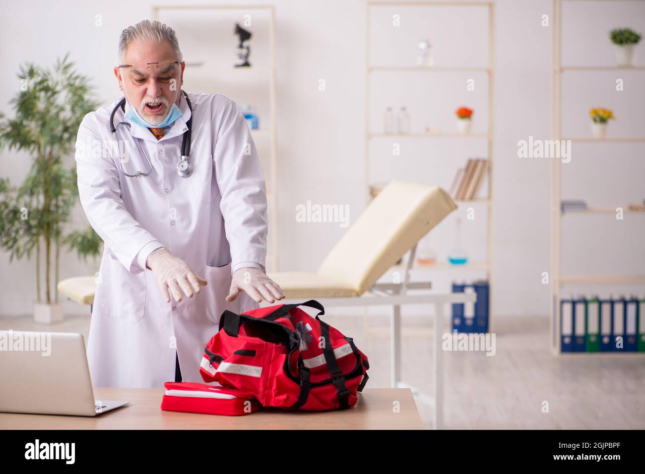 Old doctor in first aid concept Stock Photo - Alamy