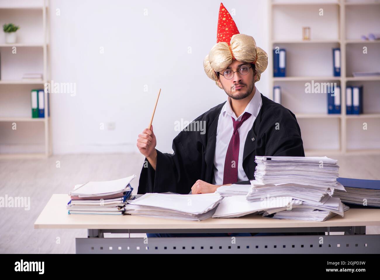 Funny young employee magician and too much work in the office Stock ...