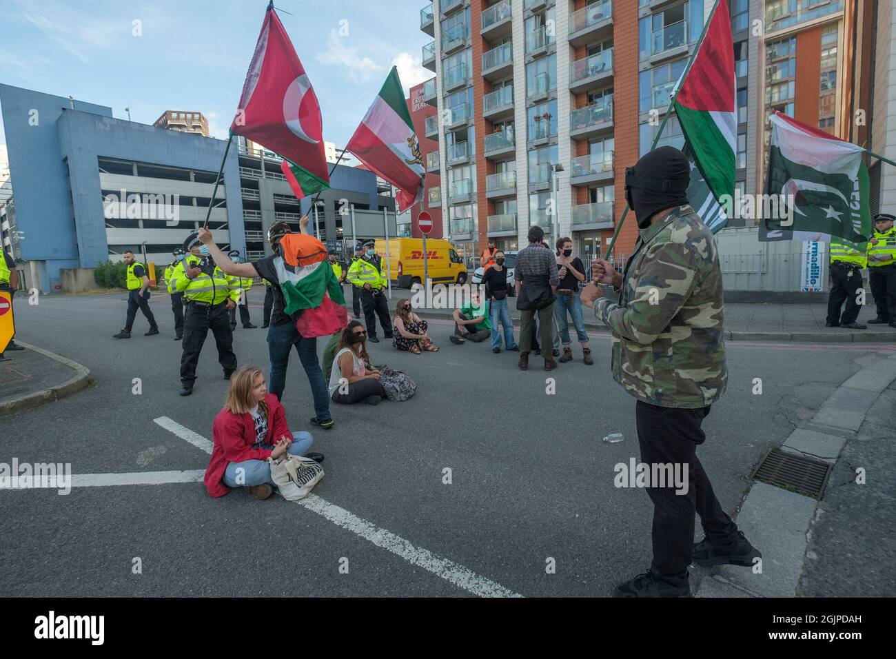 London, UK. 21st Sep 2021. Three masked protesters with flags arrive at ...