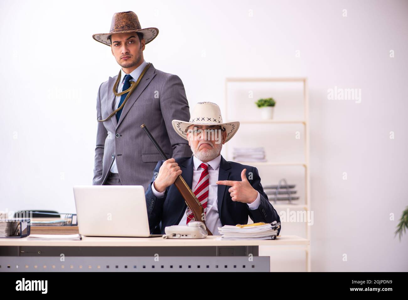 Two cowboy employees in funny concept Stock Photo - Alamy