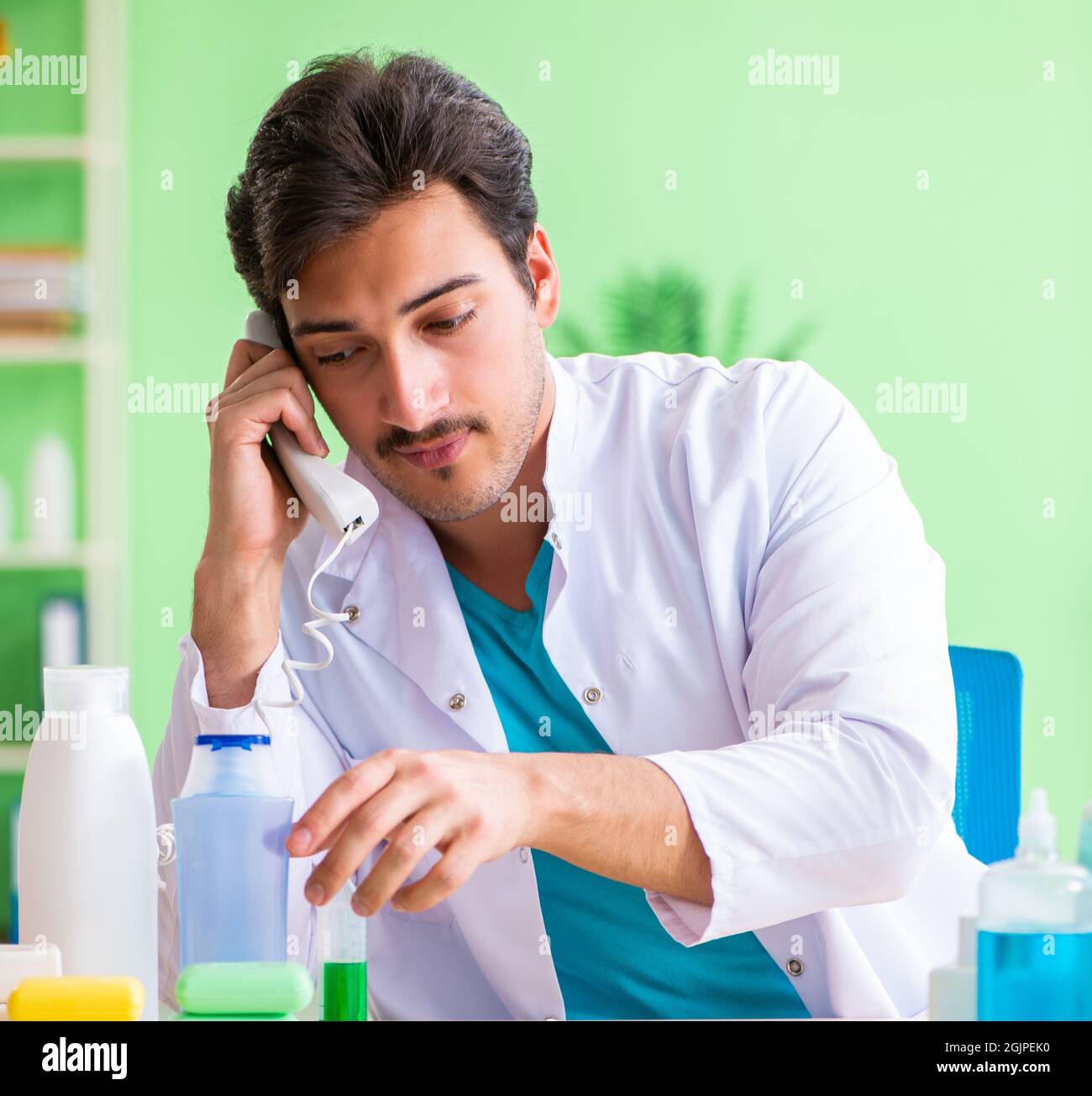 Chemist examining liquid solution speaking hi-res stock photography and ...