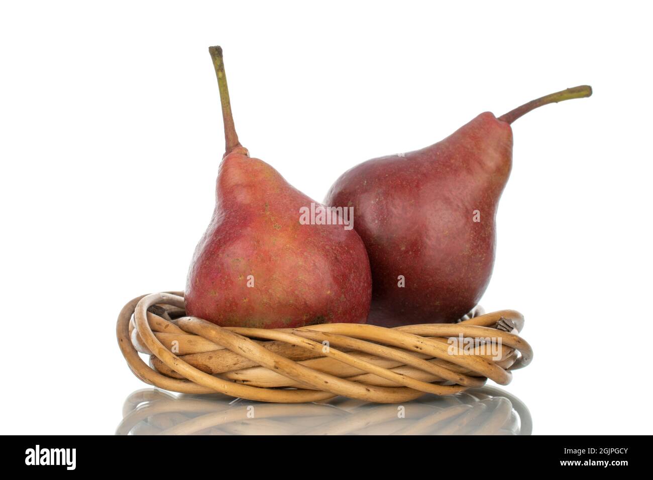 Two ripe red pears with a vine wreath, close-up, isolated on white ...