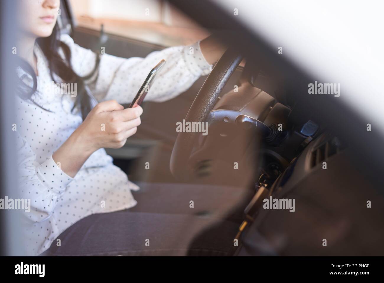 Young multiracial woman texting and driving car. Woman using cellphone ...