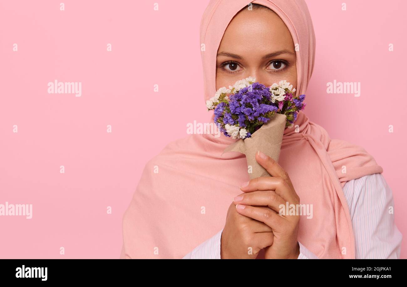 Close-up headshot portrait of young charming Arab Muslim woman in pink ...