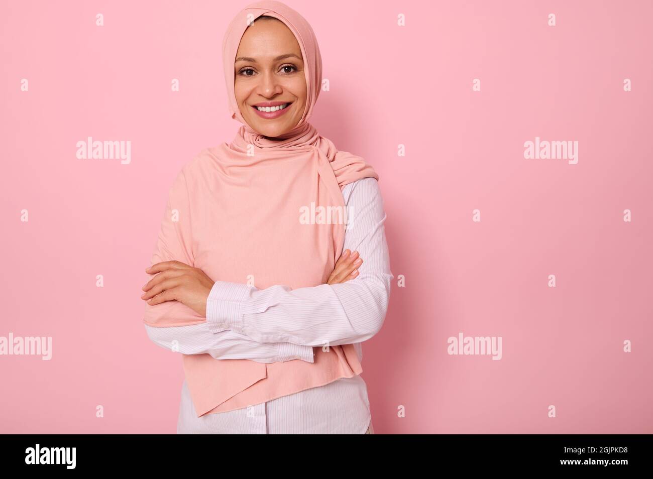 Waist-length portrait of a beautiful Arabic Muslim woman in pink hijab ...