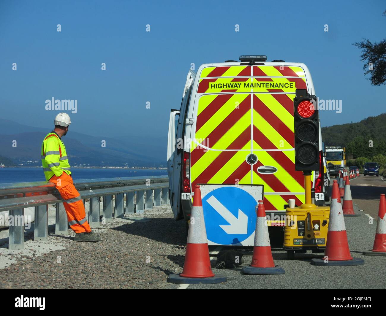 Highway maintenance in the Scottish Highlands: workman admires the view ...