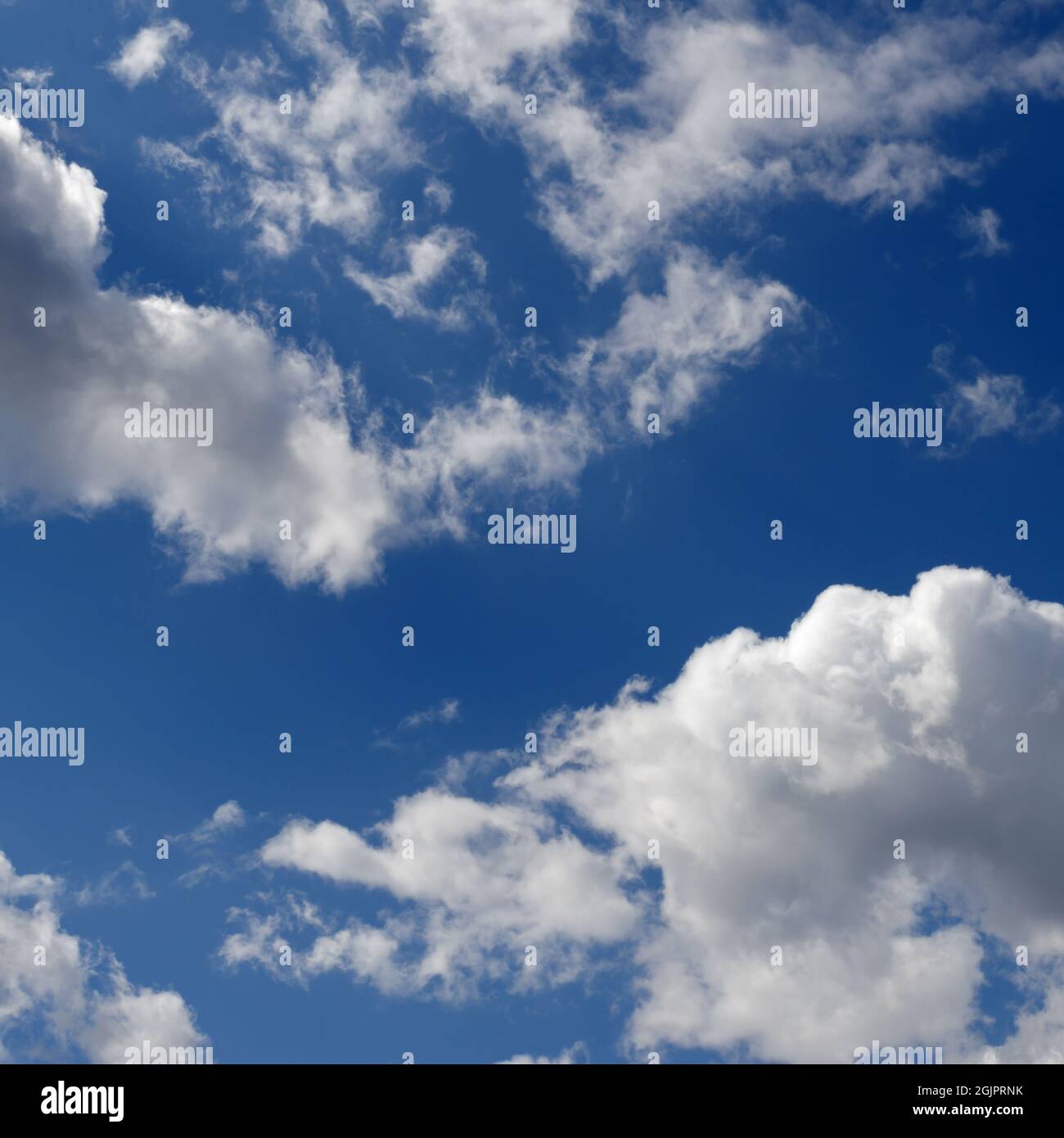 Blue sky with white clouds backlit by sunlight. Fluffy cumulus clouds ...