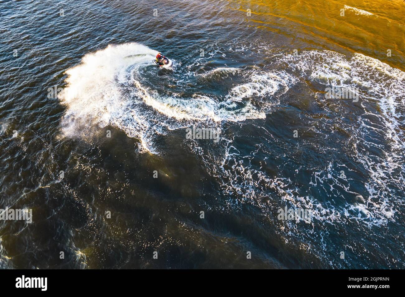 Aerial view of Young man making infinite loop riding on fast water ...