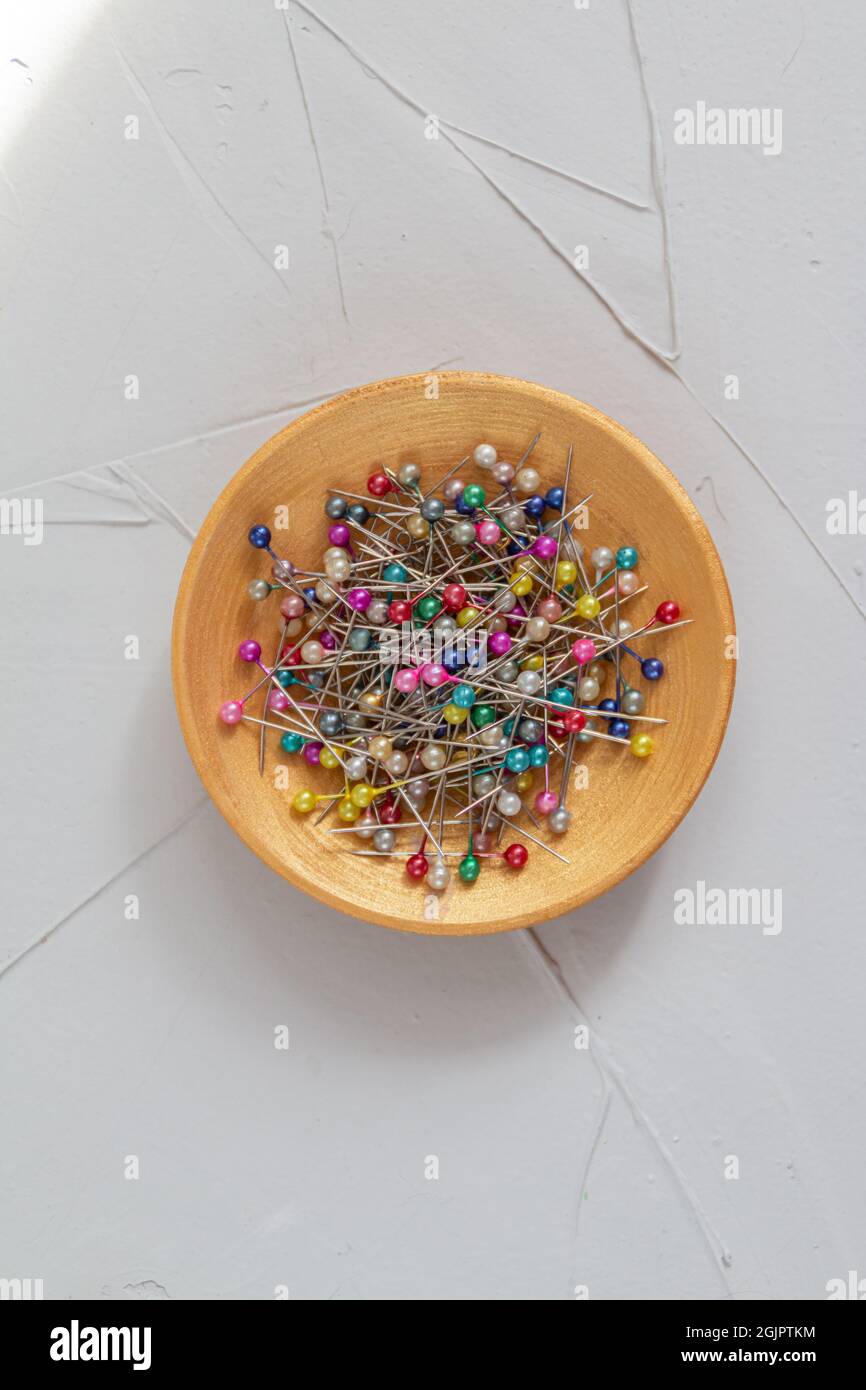 colored sewing pins in a golden plate against grey background Stock ...