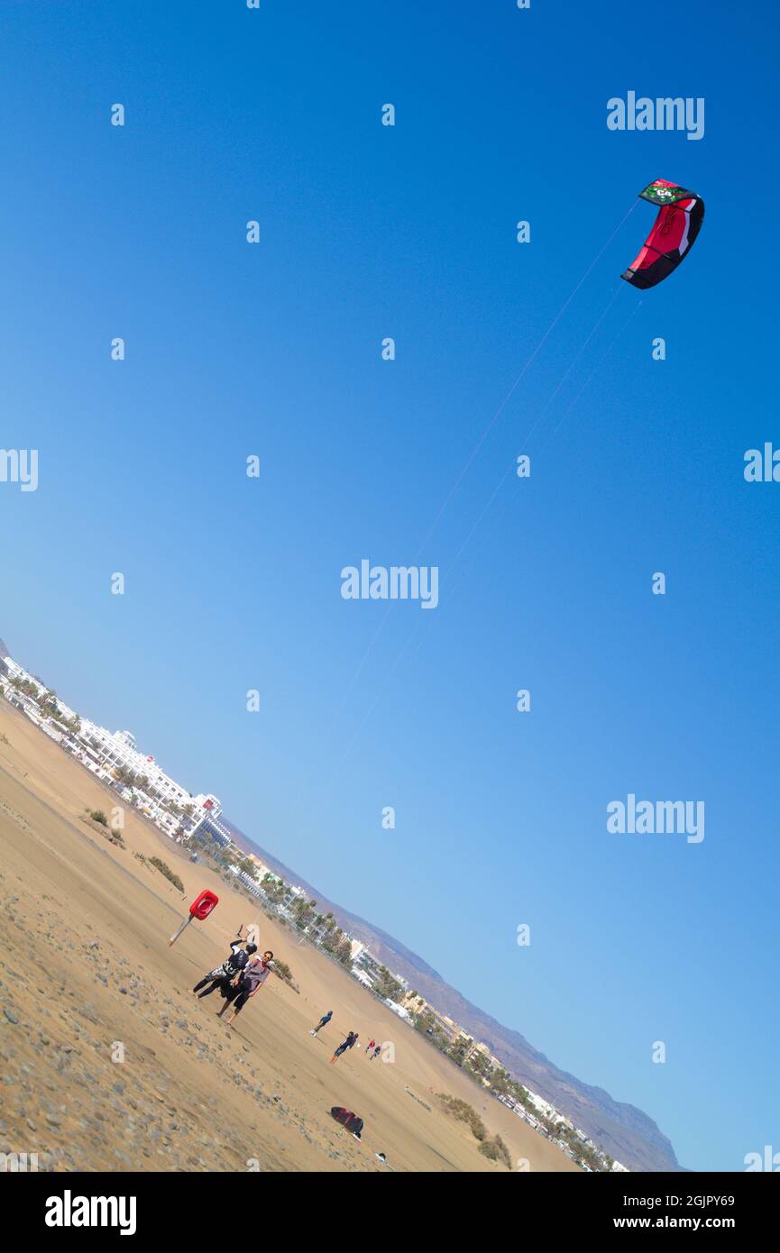Red and black paraglider flying in the blue sky Stock Photo - Alamy