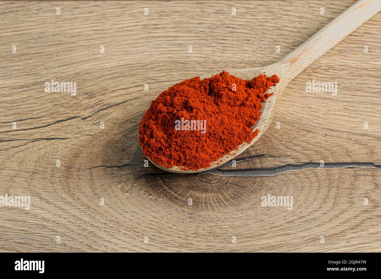 Spoonful of red pepper on the wooden surface Stock Photo - Alamy