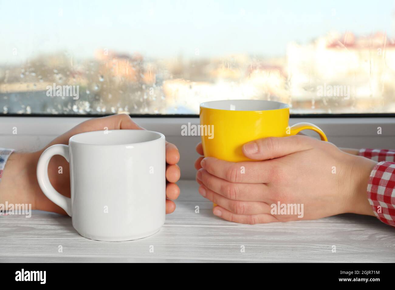 People holding cups against window Stock Photo - Alamy
