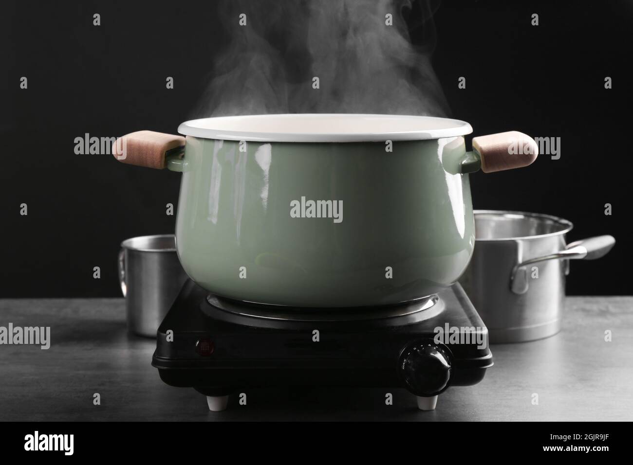 Cooking rice in metal pan on hotplate in kitchen Stock Photo - Alamy
