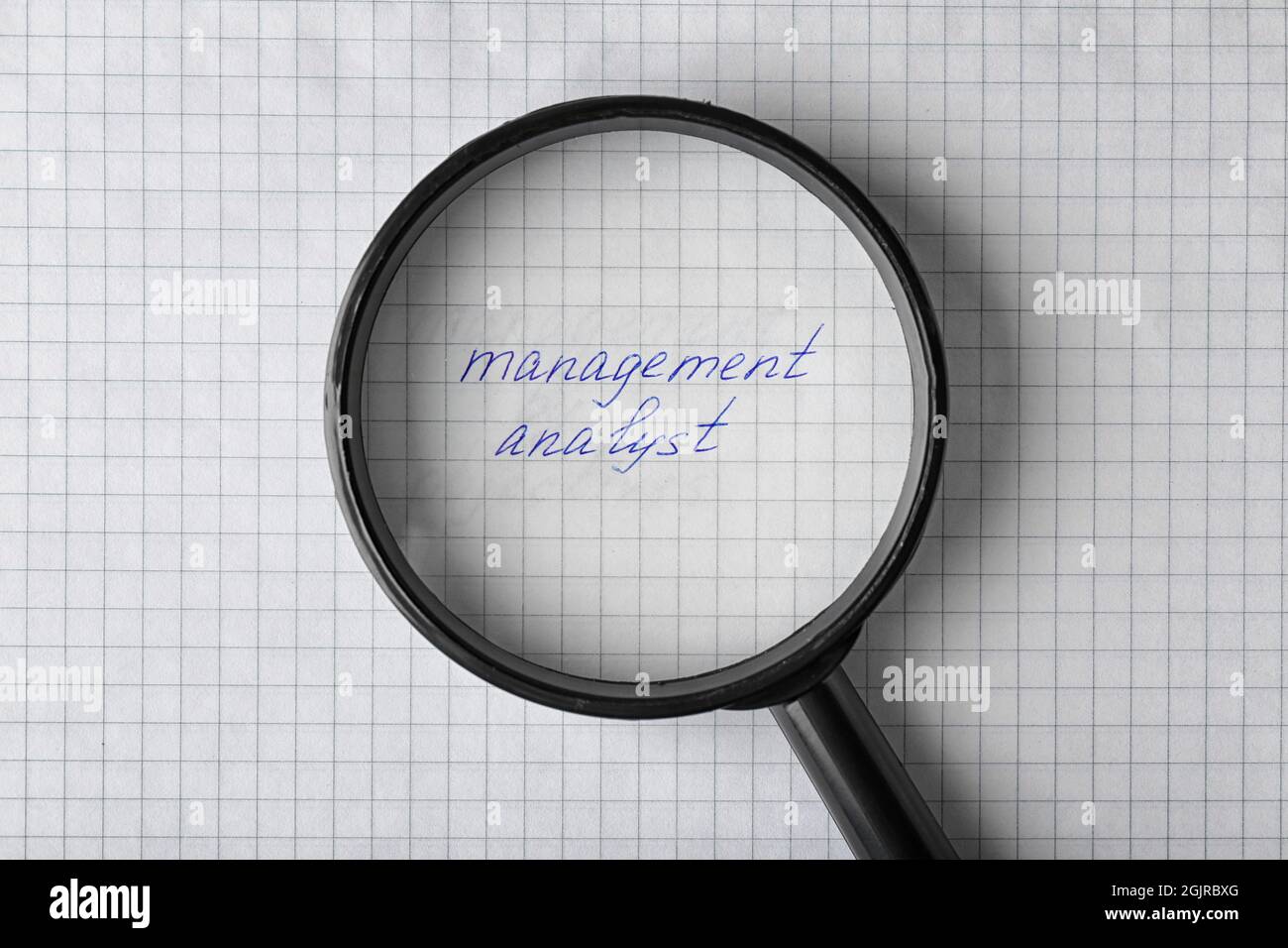 Text MANAGEMENT ANALYST under magnifier on paper sheet background Stock ...