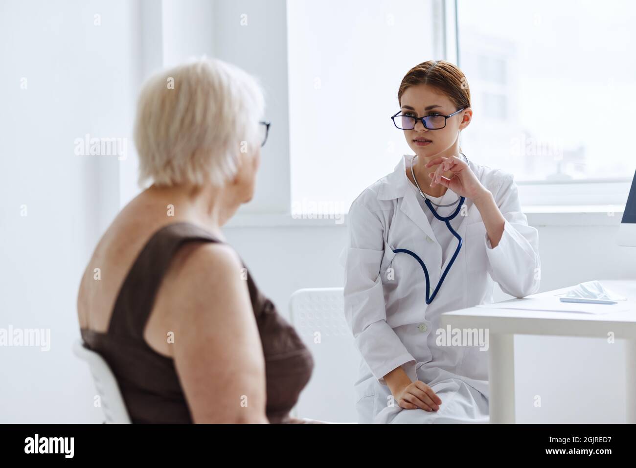 patient consults with a doctor doctor assistant Stock Photo - Alamy