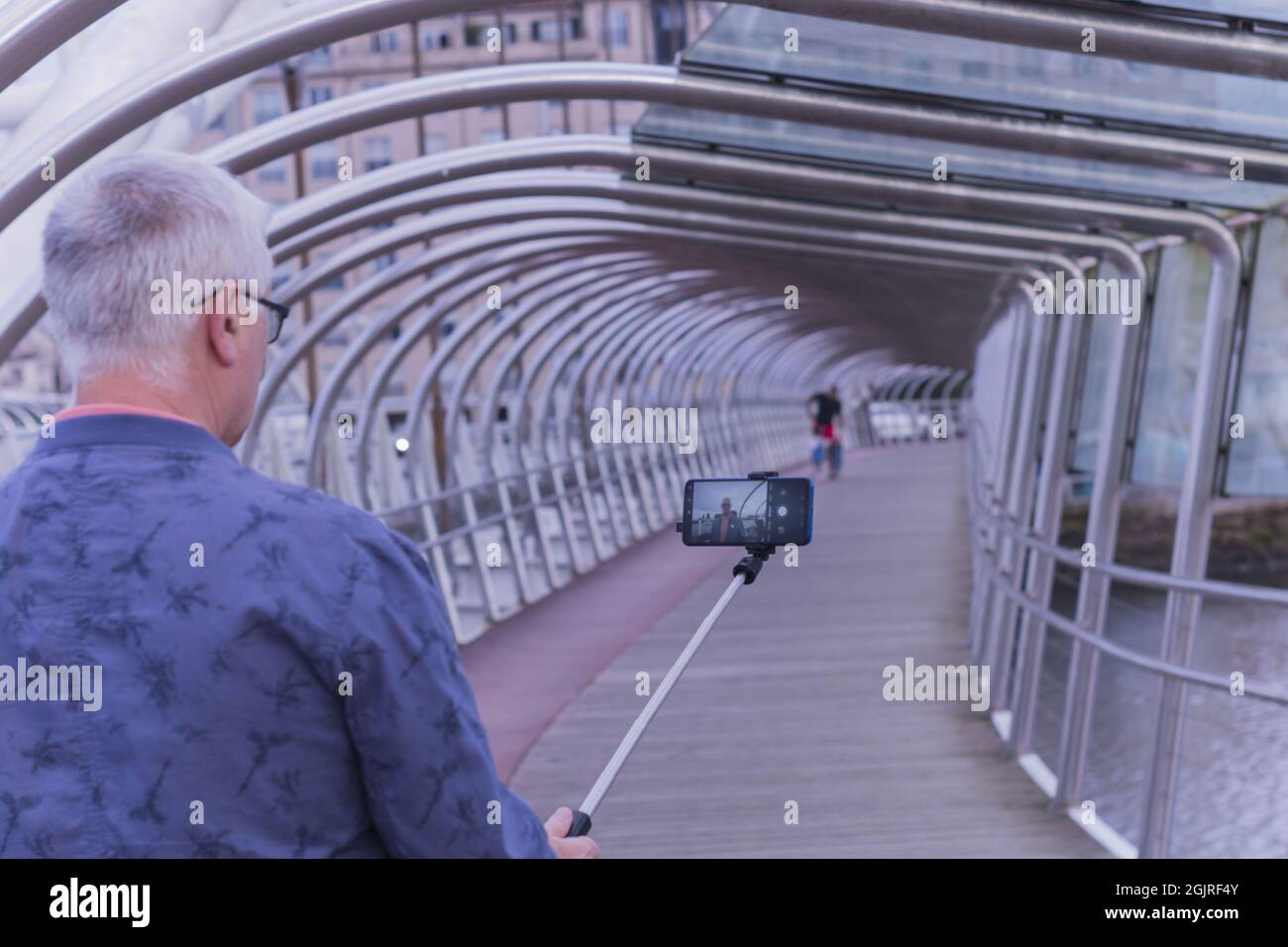 Adult Spanish man with white hair taking a selfie with a selfie stick ...