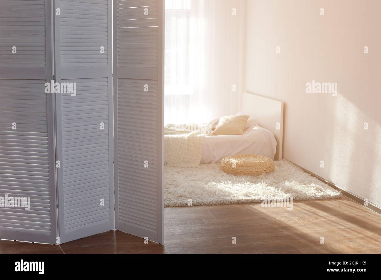 Interior of beautiful room with folding screen and bed Stock Photo - Alamy