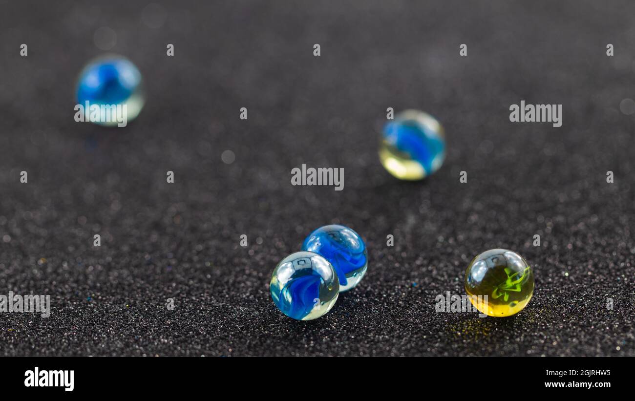 coloured glass marbles scattered on black background Stock Photo - Alamy