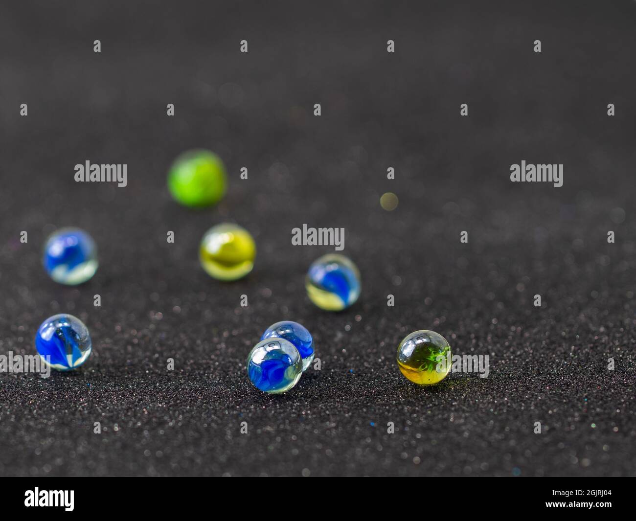 coloured glass marbles scattered on black background Stock Photo - Alamy