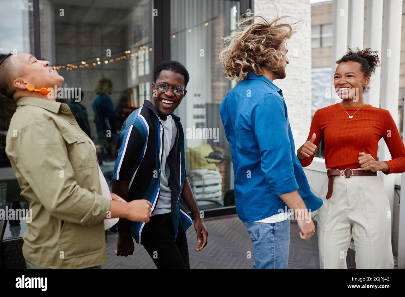 Diverse group of young people dancing and having fun while enjoying ...